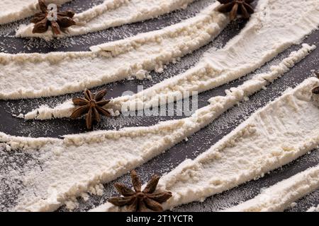 Anis seeds and christmas tree shape in flour with copy space on black ...