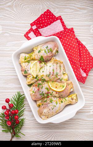 Marinated chicken legs with raw new potatoes and garlic in a glass dish ...