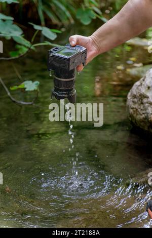 A reflex camera accidentally falls into the river, a man pulls it out ...