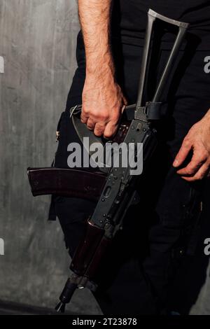 A man holds a Kalashnikov assault rifle in his hands for firing from ...