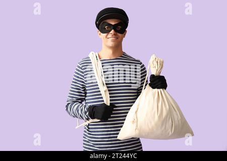 Male thief with bag and rope on lilac background Stock Photo - Alamy