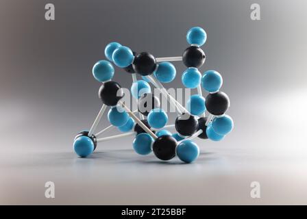 Molecular model structure, miniature on grey background, blue and black ...