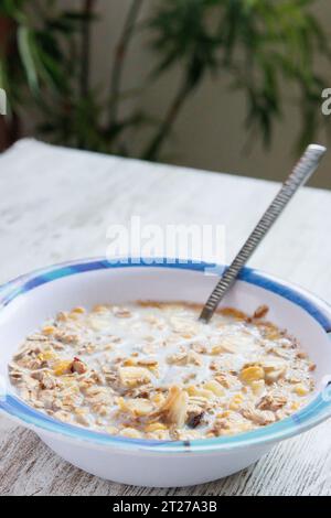 vertical image of a bowl with oatmeal and banana accompanied by a glass ...
