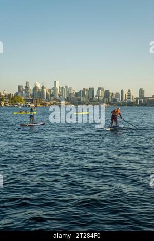 People paddle boarding and kayaking on Lake Union with the Seattle ...