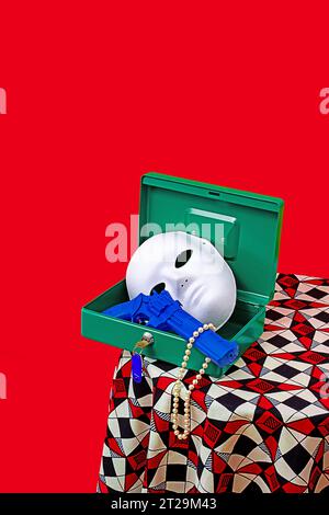 Opened secret box with mask, toy gun and tinsel placed on table against ...