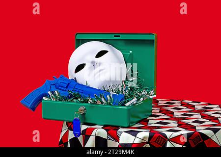 Opened secret box with mask, toy gun and tinsel placed on table against ...