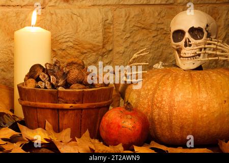 Halloween composition with pumpkin, skull, and candles on a white ...