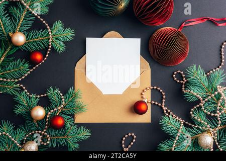 Blank postcard, envelope and fir branches on a wooden background, flat ...