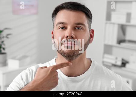 Endocrine system. Man doing thyroid self examination on white ...