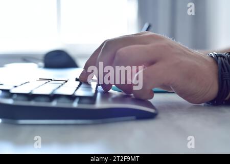 Designer working with wheel manipulator keyboard in home office ...