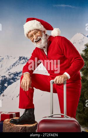 Happy caucasian man wearing santa hat, sitting at table in kitchen ...