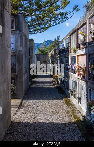 Wall with graves and ladder with wheels in a cemetery, Bari Sardo ...