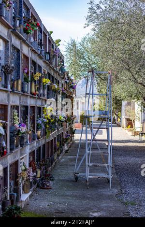 Wall with graves and ladder with wheels in a cemetery, Bari Sardo ...