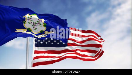 Connecticut and the United states flags waving in the wind on a clear ...