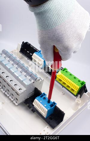 An electrician installs fuses on the TH35 rail in the electrical ...