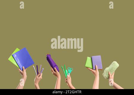 Many hands holding school supplies on light blue background Stock Photo ...