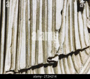 ancient texture. beige stone, voluminous background. a statue in robes ...