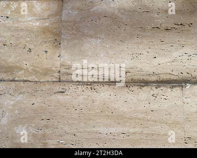 Textured wall lined with beige shell rock tiles. Close-up of a wall ...