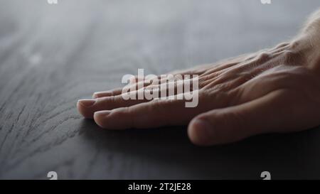 man hand touches black oak table surface, wide photo Stock Photo - Alamy
