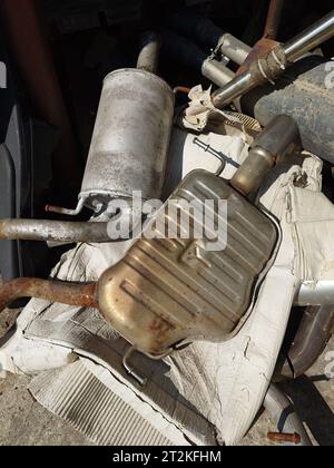 Broken exhaust and muffler of a car, rusted silencer fallen down on the ...