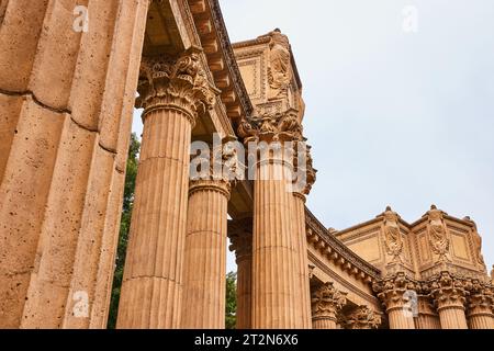 Upward view of Roman styled colonnade architecture with tree tops on ...
