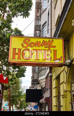 Sonny Hotel bright yellow sign with orange lettering on grimy building ...