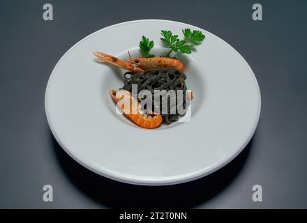 Cuttlefish ink tagliolini with scampi, a typical dish of Italian ...