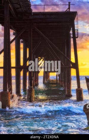 Colourful seascape sunrise at historic timber jetty of Middle Camp ...