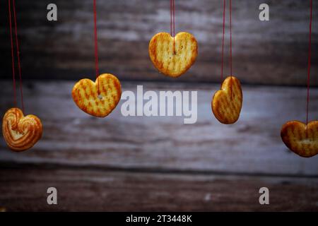 A few love shaped biscuits are hanging on the string Stock Photo - Alamy