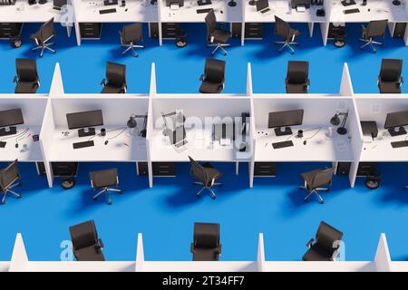 High-angle view of cubicles with tables, chairs, and computers in a modern office building. A ...