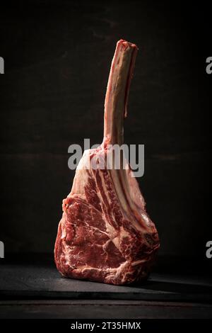 Close-up image of a Tomahawk steak or pork chop steak on wooden board ...