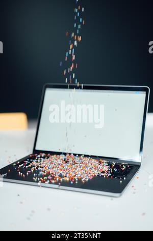 Multi colored pearls on laptop at desk Stock Photo - Alamy