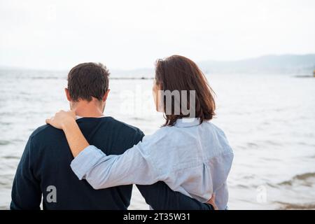 Positive couple standing together in fruit and vegetable section of ...