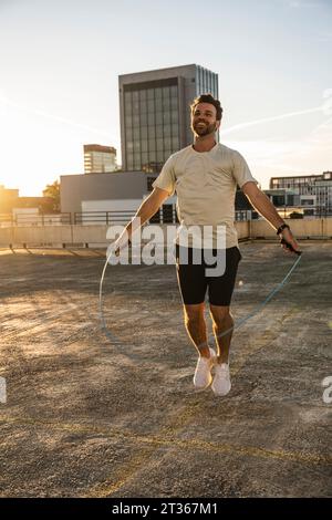 Man jumping over rope at terrace Stock Photo - Alamy