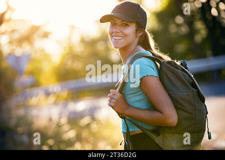 Portrait of happy young woman with backpack at college campus Stock ...