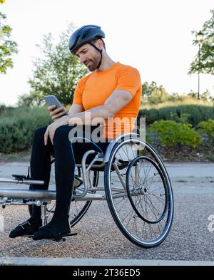 Mature man with disability using smart phone sitting on steps Stock ...