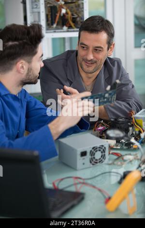 Trainee technician learning to repair computer Stock Photo - Alamy