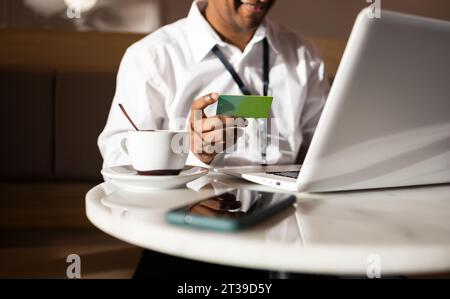 Soft focus of anonymous male with cup of coffee browsing cellphone ...