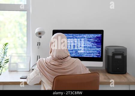 Muslim female programmer working in office, back view Stock Photo - Alamy