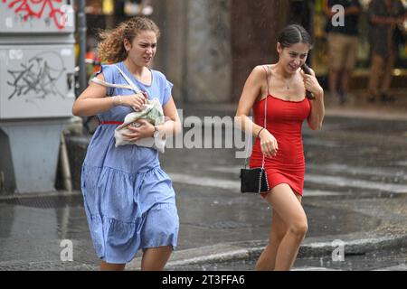 Italian young girls crossing the street in the rain. Via Ugo Bassi ...