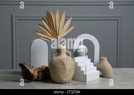 Clay flagon and other decorative elements on grey textured table, space ...