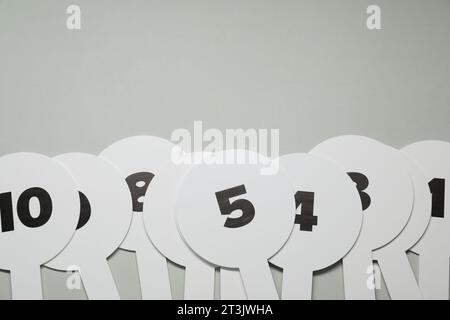 Auction paddles with numbers on light blue background, top view. Space ...