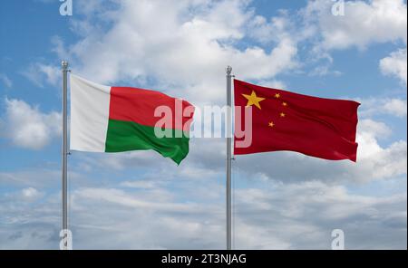 Madagascar and China flags waving together on blue cloudy sky, two ...