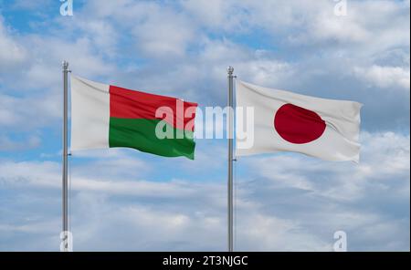Madagascar flag and Japan flag waving together on blue sky, two country ...