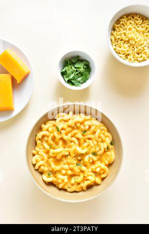 Mac and cheese in bowl over light stone background with copy space. Top ...