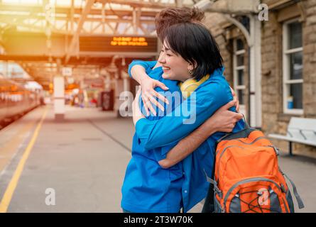 Beautiful couple at the railway station hugging, meeting and waiting ...