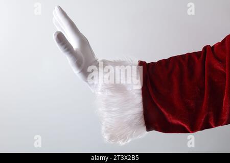 Santa claus hand with white glove and red traditional costume making ...