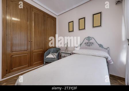 Hotel single Room with a bed, an armchair and a table with men's black ...