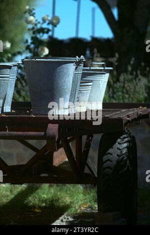 Tin buckets on a carriage in a garden Stock Photo - Alamy