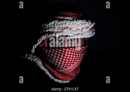 portrait of pearson wearing red keffiyeh on dark background with anger ...